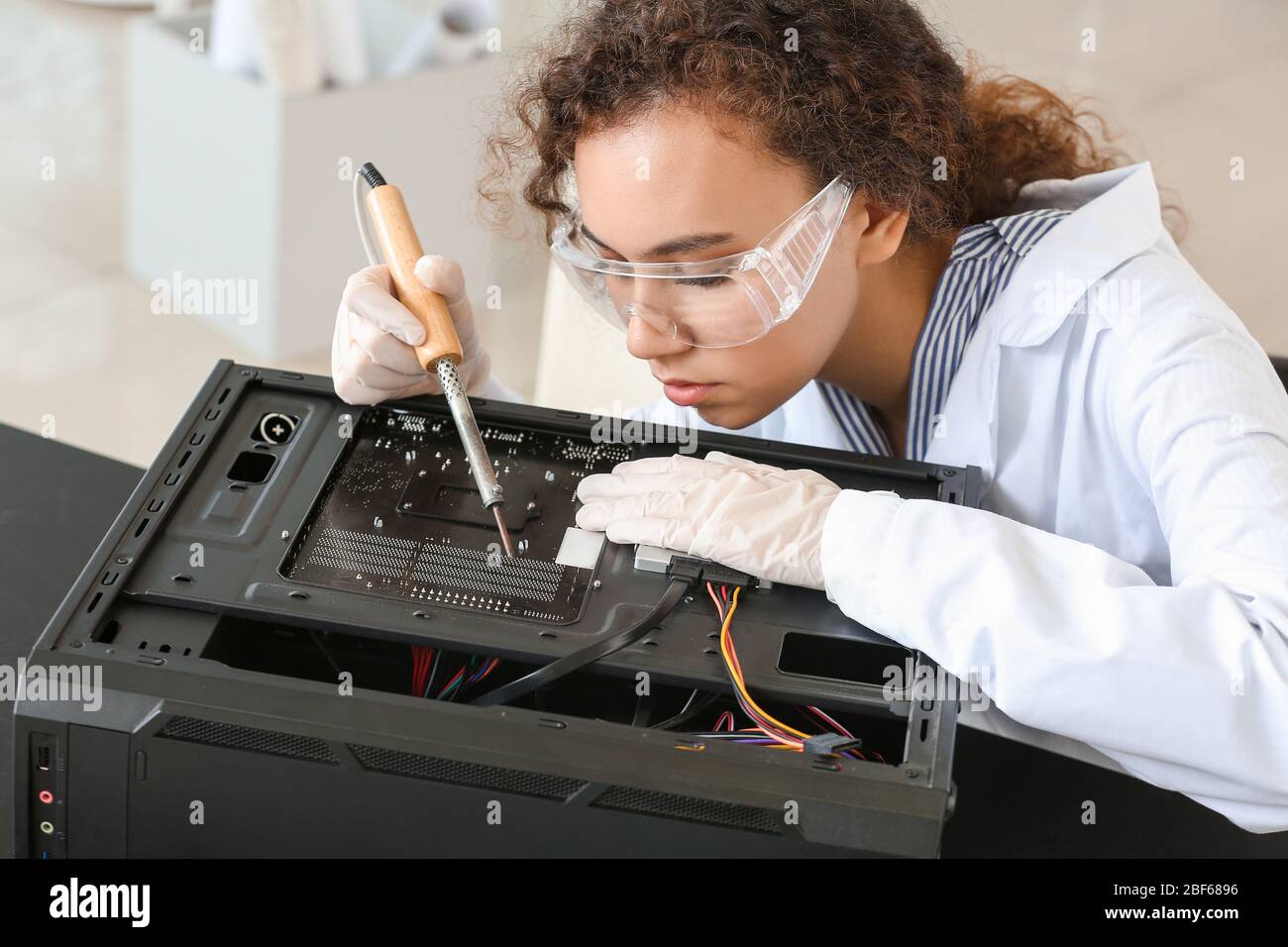 Electronic technician working in service center Stock Photo - Alamy