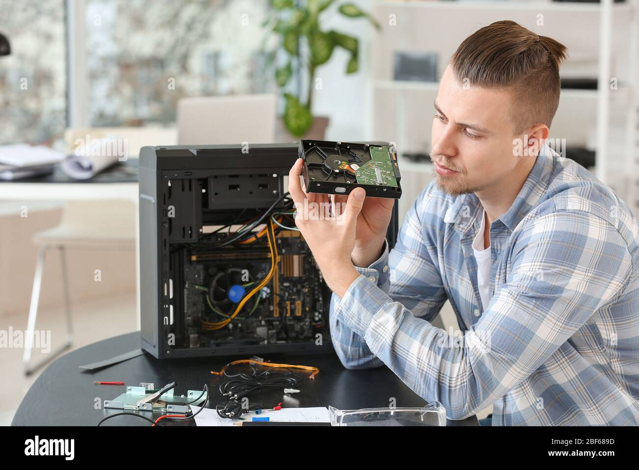 Electronic technician working in service center Stock Photo - Alamy