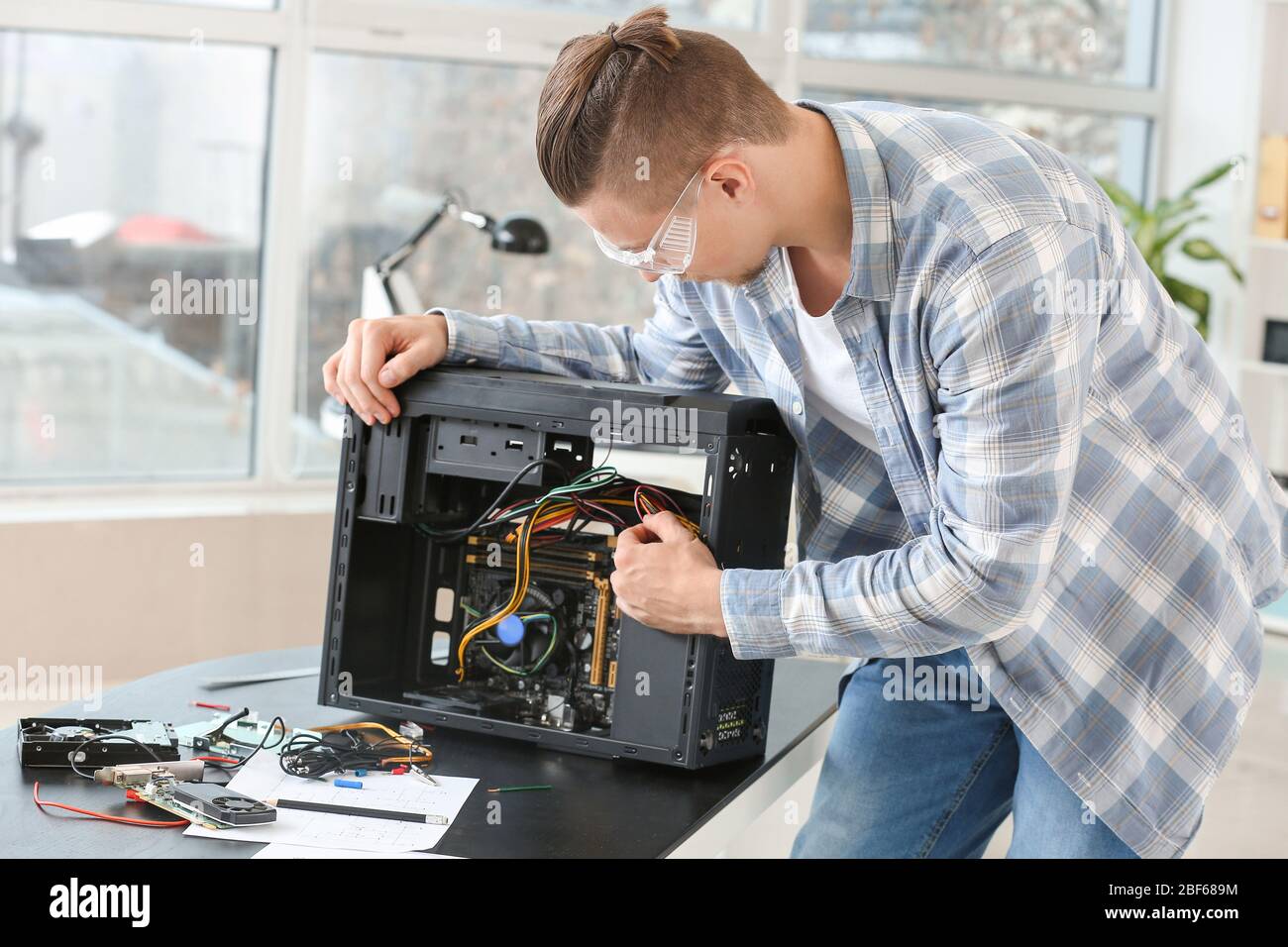 Electronic technician working in service center Stock Photo - Alamy