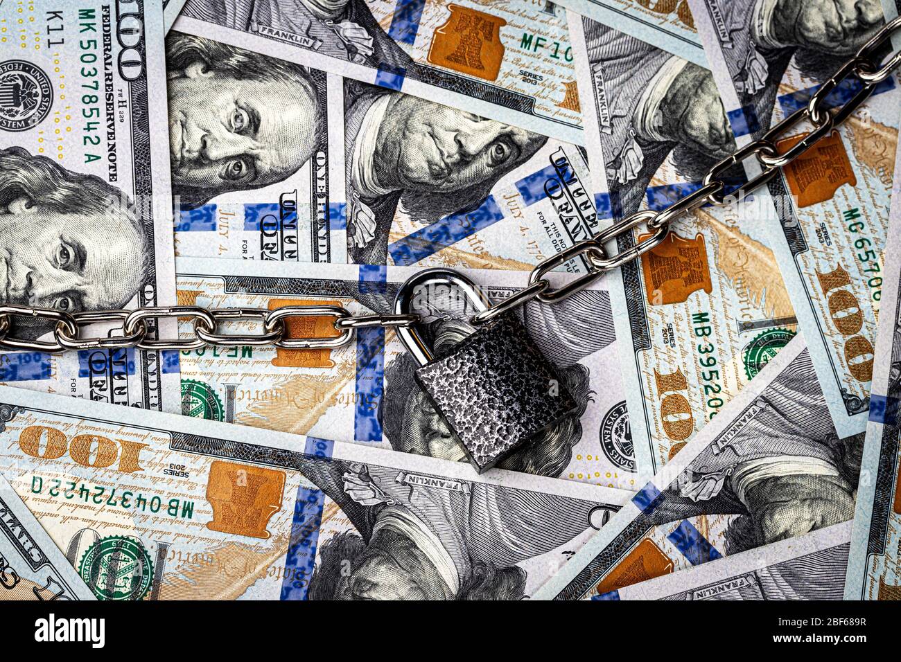 Dollar bills, black lock and metal chain. Money lock or security ...