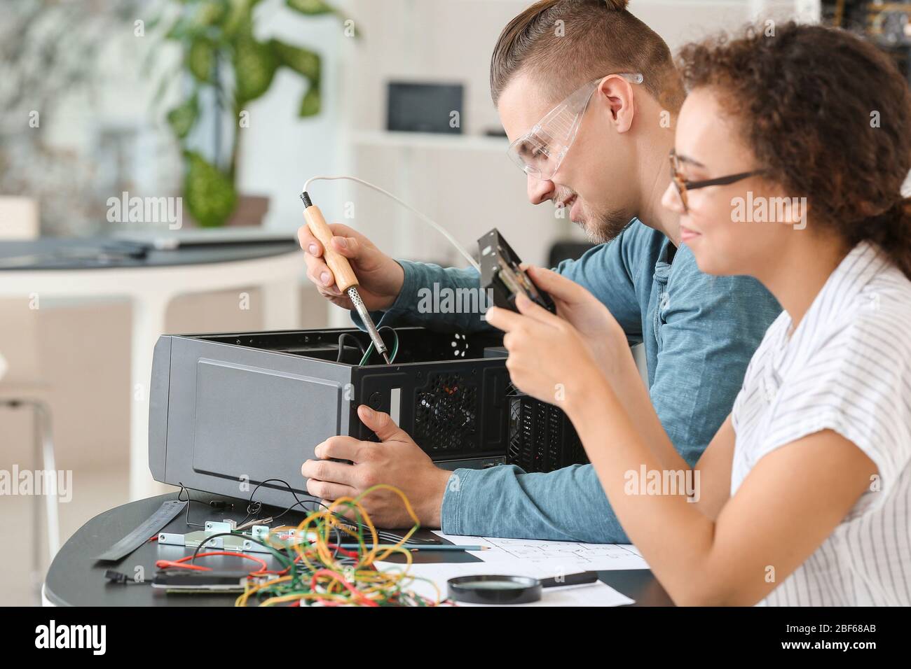 Electronic technicians working in service center Stock Photo - Alamy