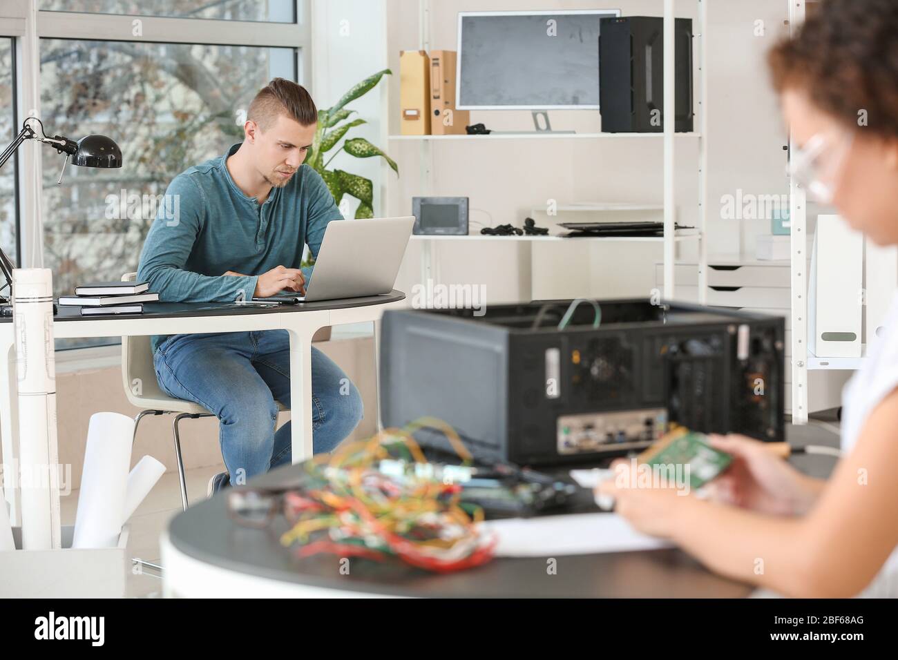 Electronic technician working in service center Stock Photo - Alamy