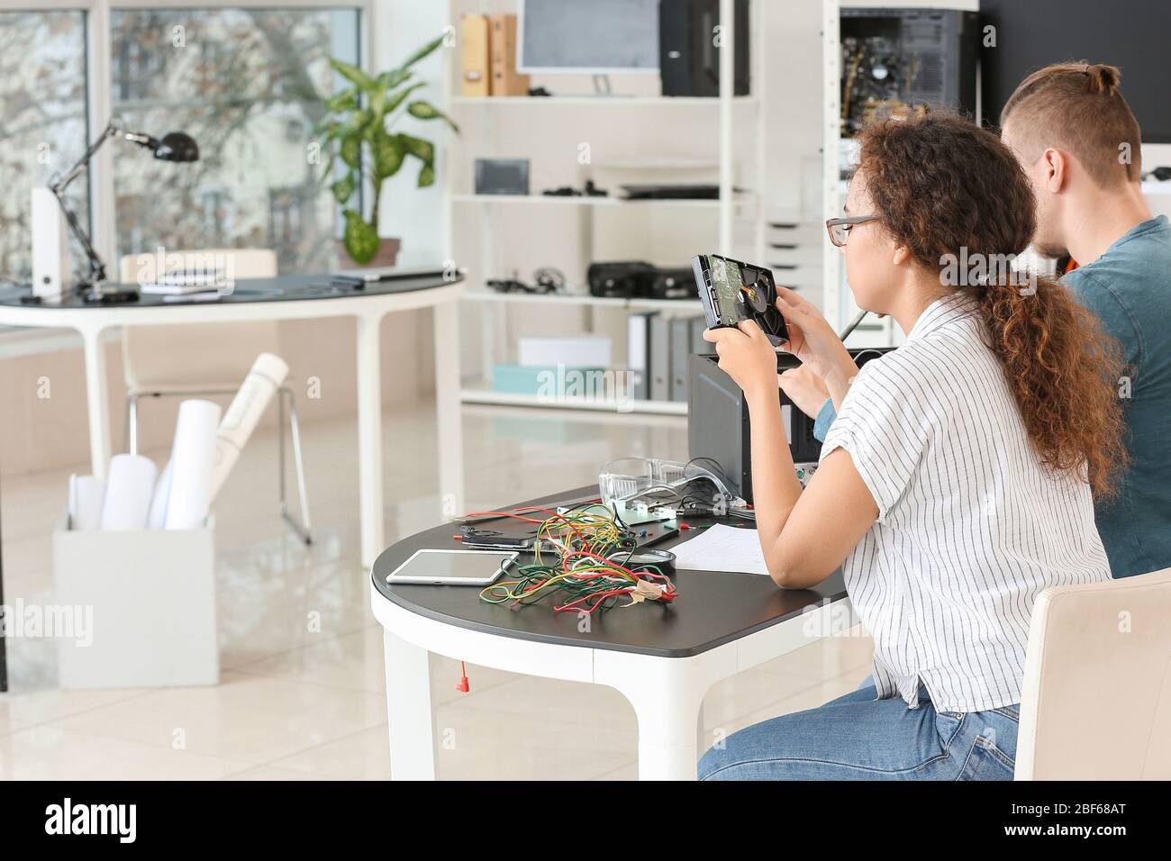 Electronic technicians working in service center Stock Photo - Alamy
