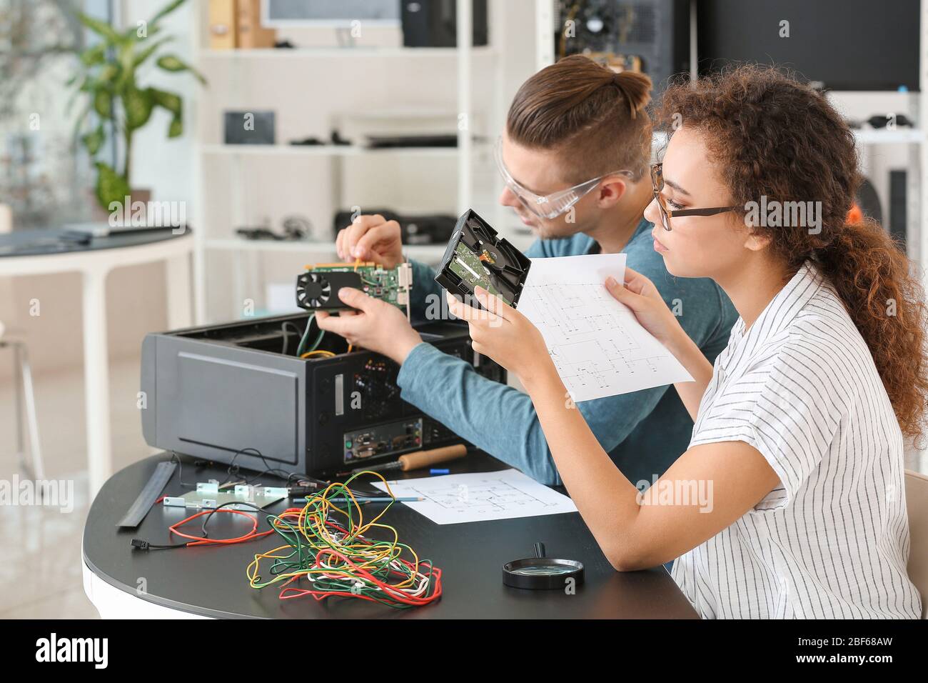 Electronic technicians working in service center Stock Photo - Alamy