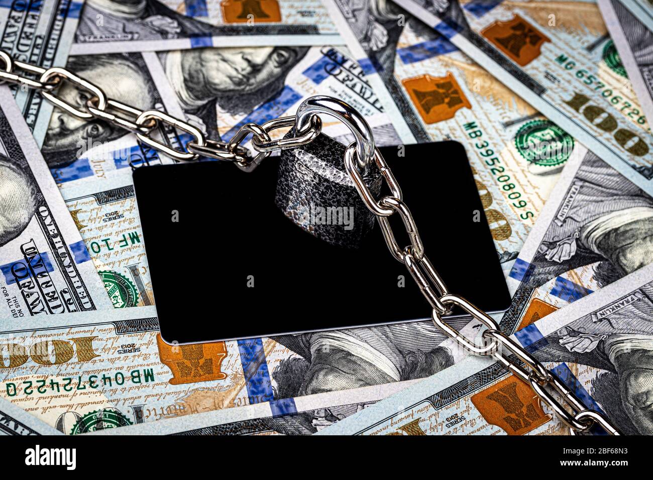 Dollar bills, lock with metal chain and black debit card. The concept ...