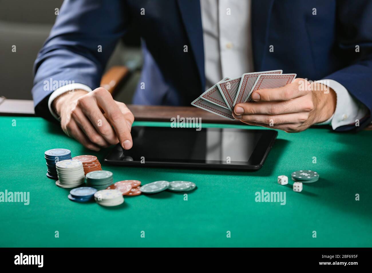 Man with tablet computer playing poker online, closeup Stock Photo - Alamy