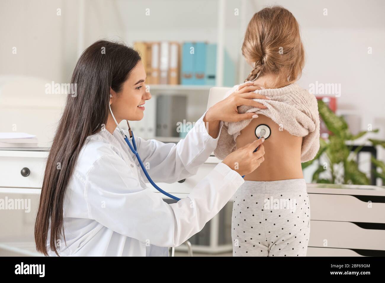 Pediatrician examining little girl in clinic Stock Photo - Alamy