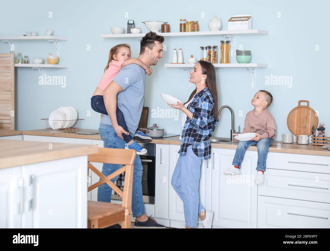 Young family washing dishes in kitchen Stock Photo - Alamy