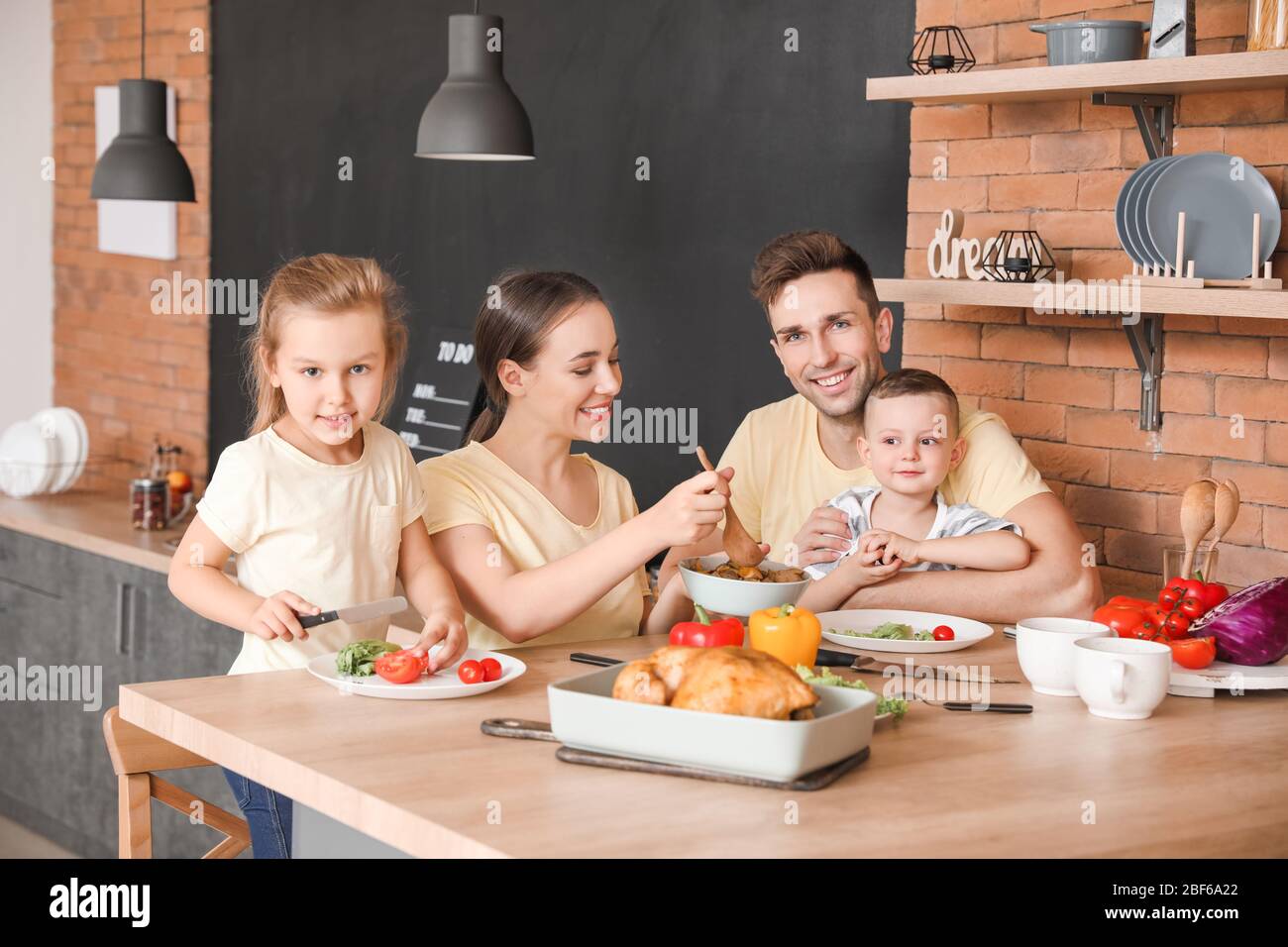 Young family having dinner in kitchen Stock Photo - Alamy