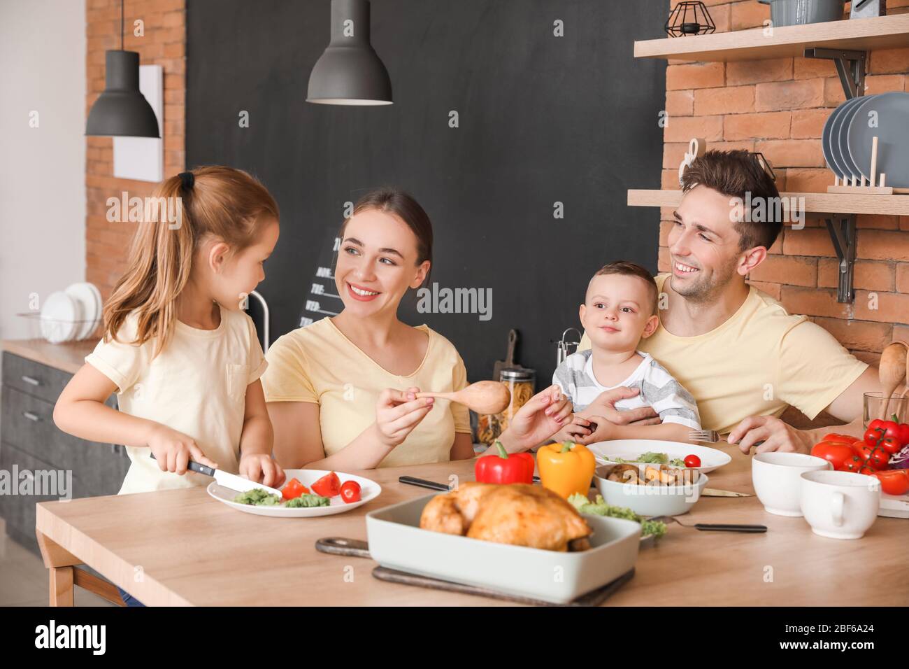 Young family having dinner in kitchen Stock Photo - Alamy