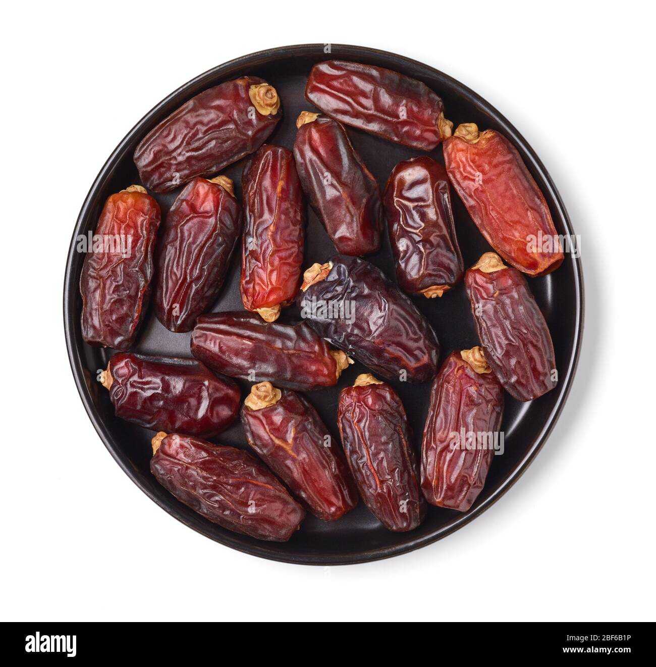 Black plate full of dates isolated on white background; top view Stock ...