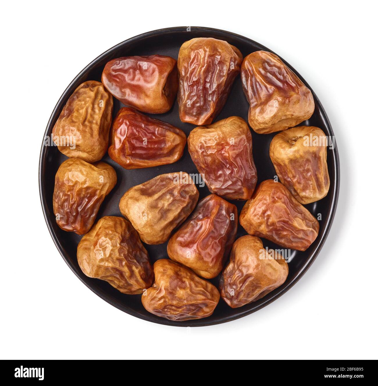 Black plate full of dates isolated on white background; top view Stock ...
