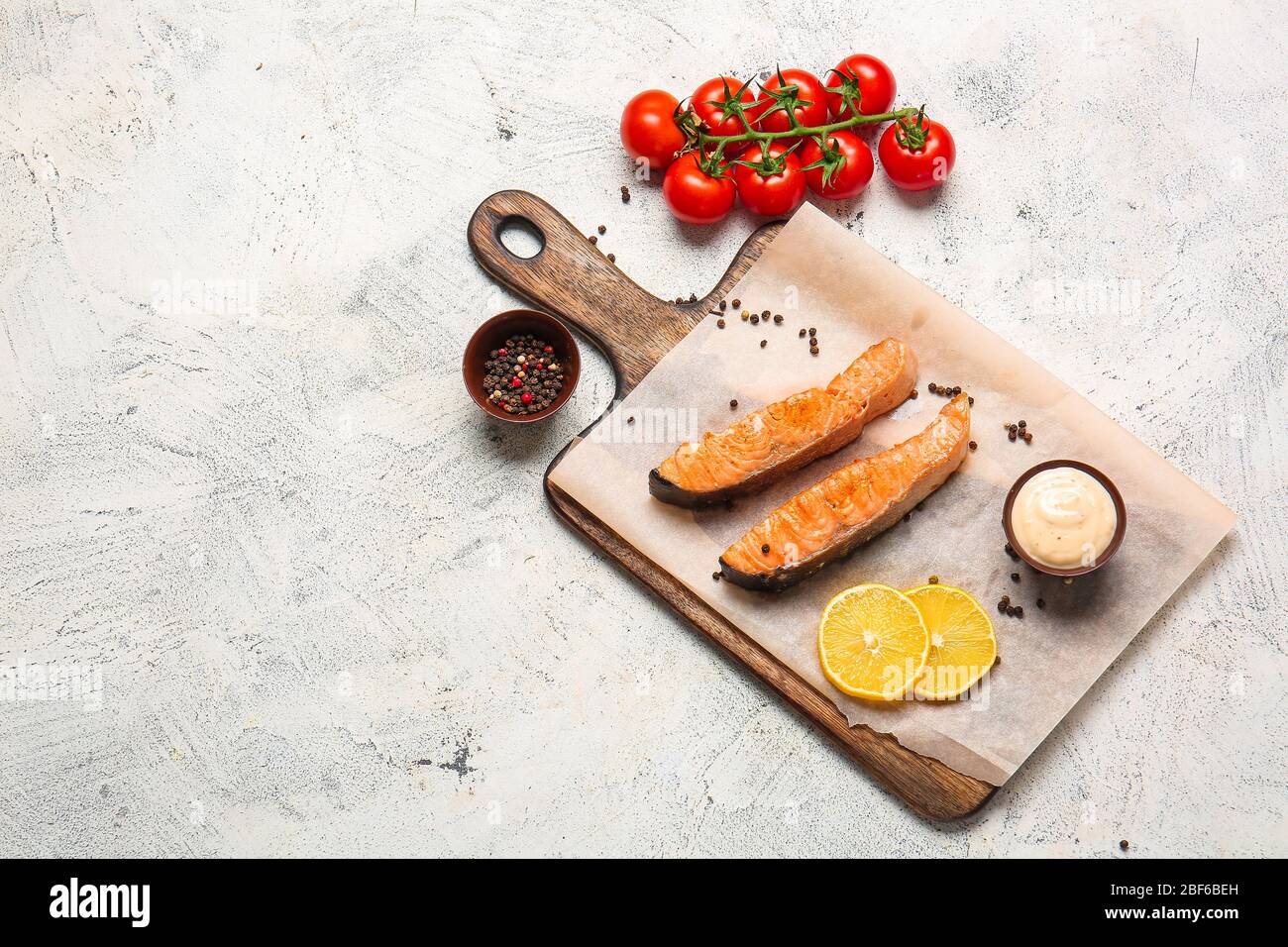 Board with tasty cooked salmon and sauce on white background Stock ...