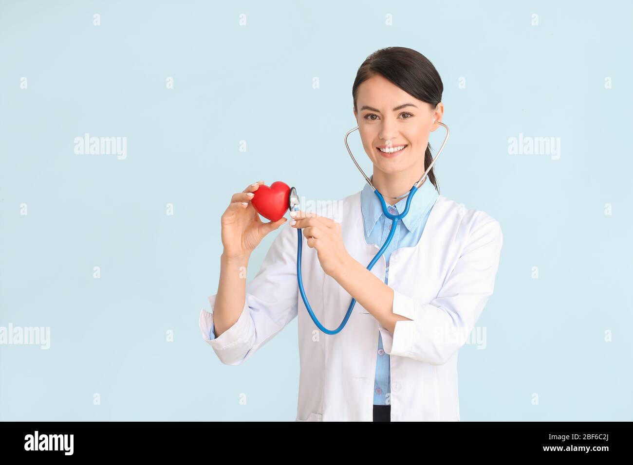 Female cardiologist on color background Stock Photo - Alamy