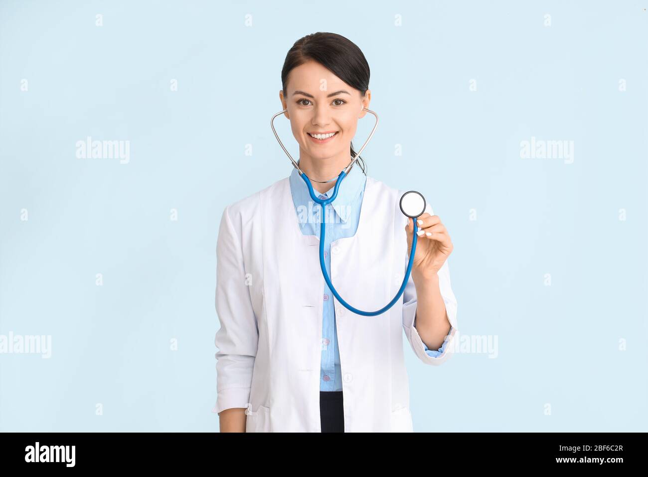 Female cardiologist on color background Stock Photo - Alamy