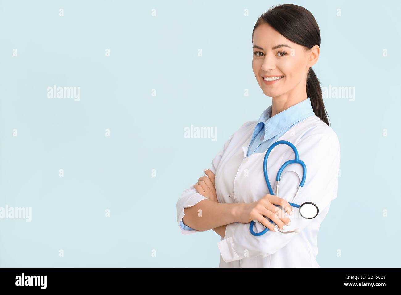 Female cardiologist on color background Stock Photo - Alamy