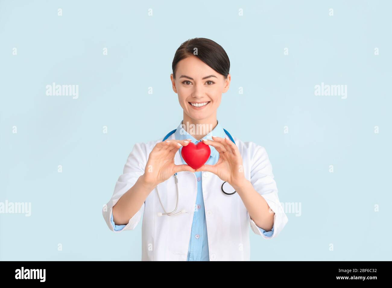 Female cardiologist on color background Stock Photo - Alamy