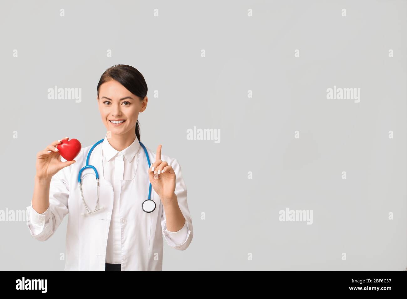 Female cardiologist on light background Stock Photo - Alamy