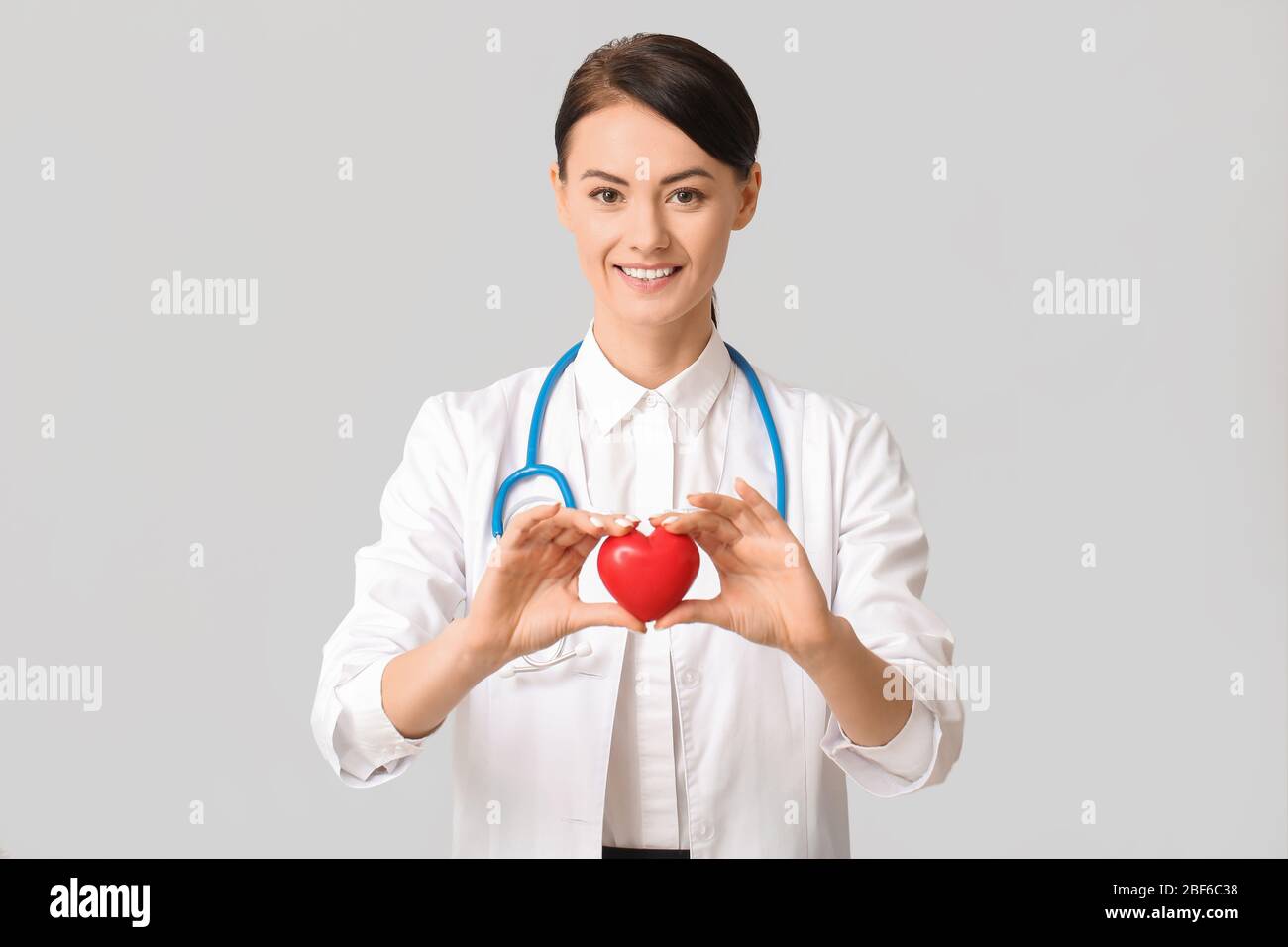 Female cardiologist on light background Stock Photo - Alamy