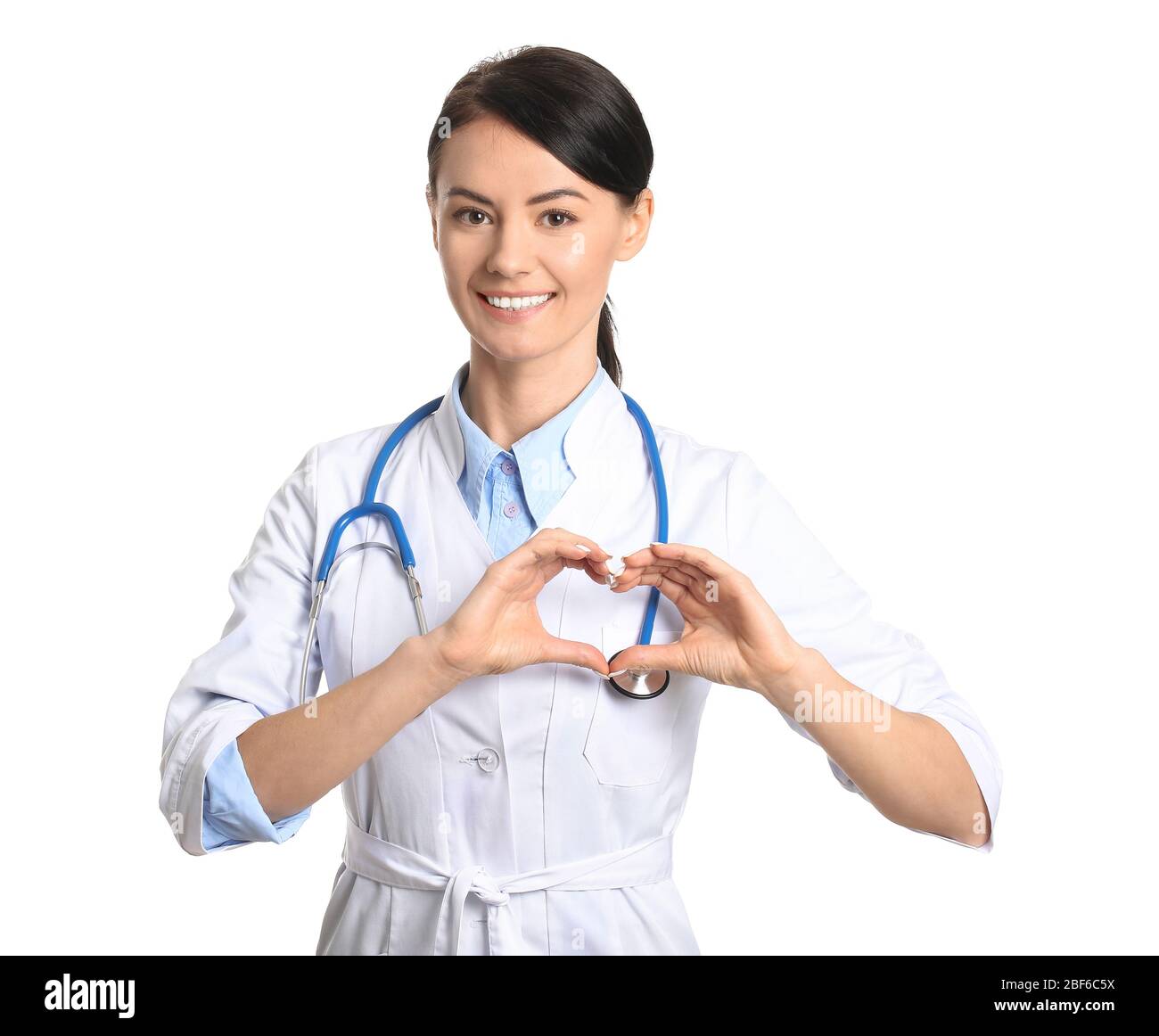 Female cardiologist making heart with her hands on white background ...