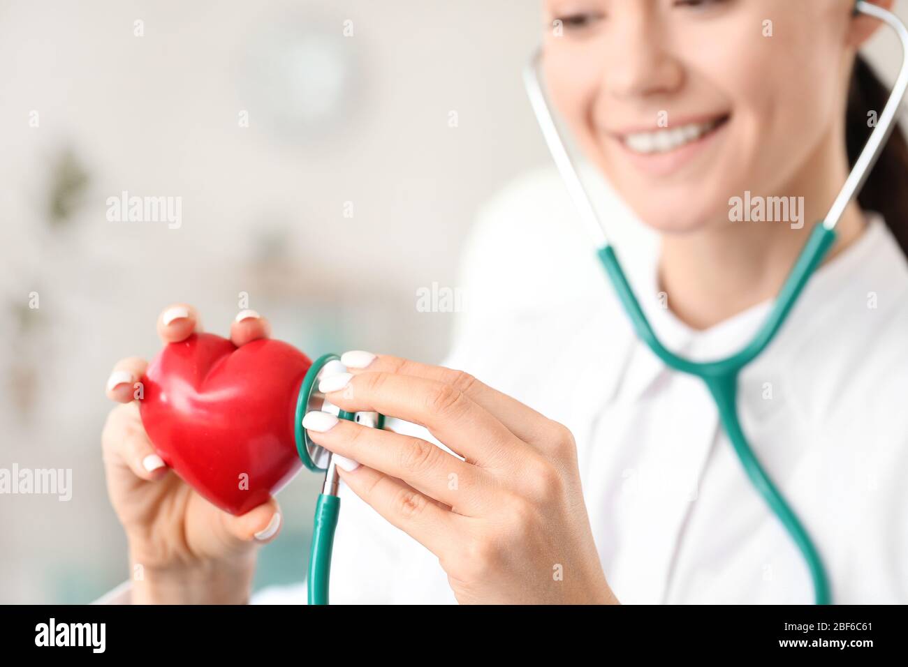 Female cardiologist with red heart in modern clinic Stock Photo - Alamy
