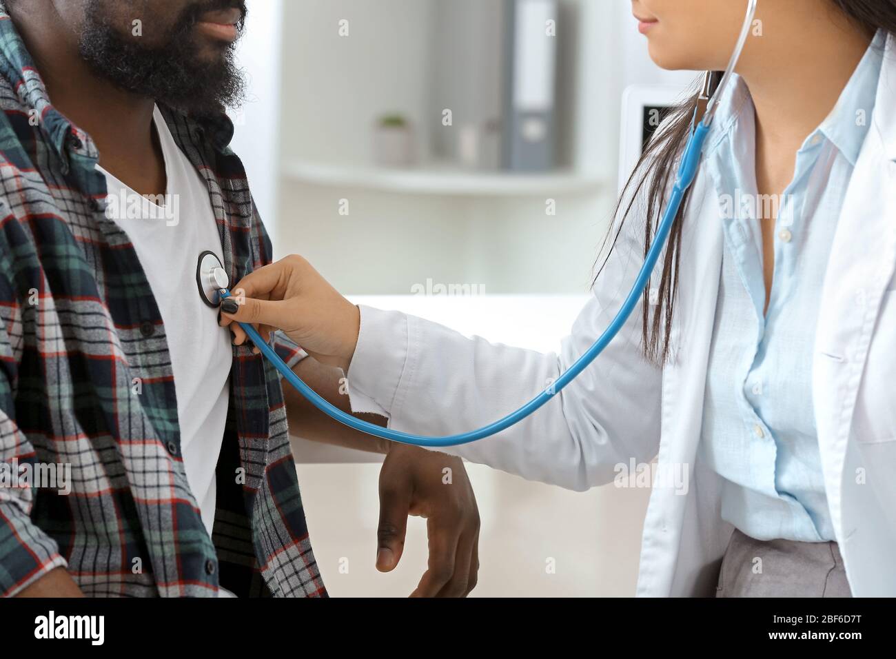 Female cardiologist examining male patient in clinic Stock Photo - Alamy