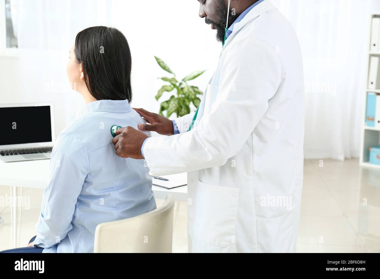 Male cardiologist examining female patient in clinic Stock Photo - Alamy