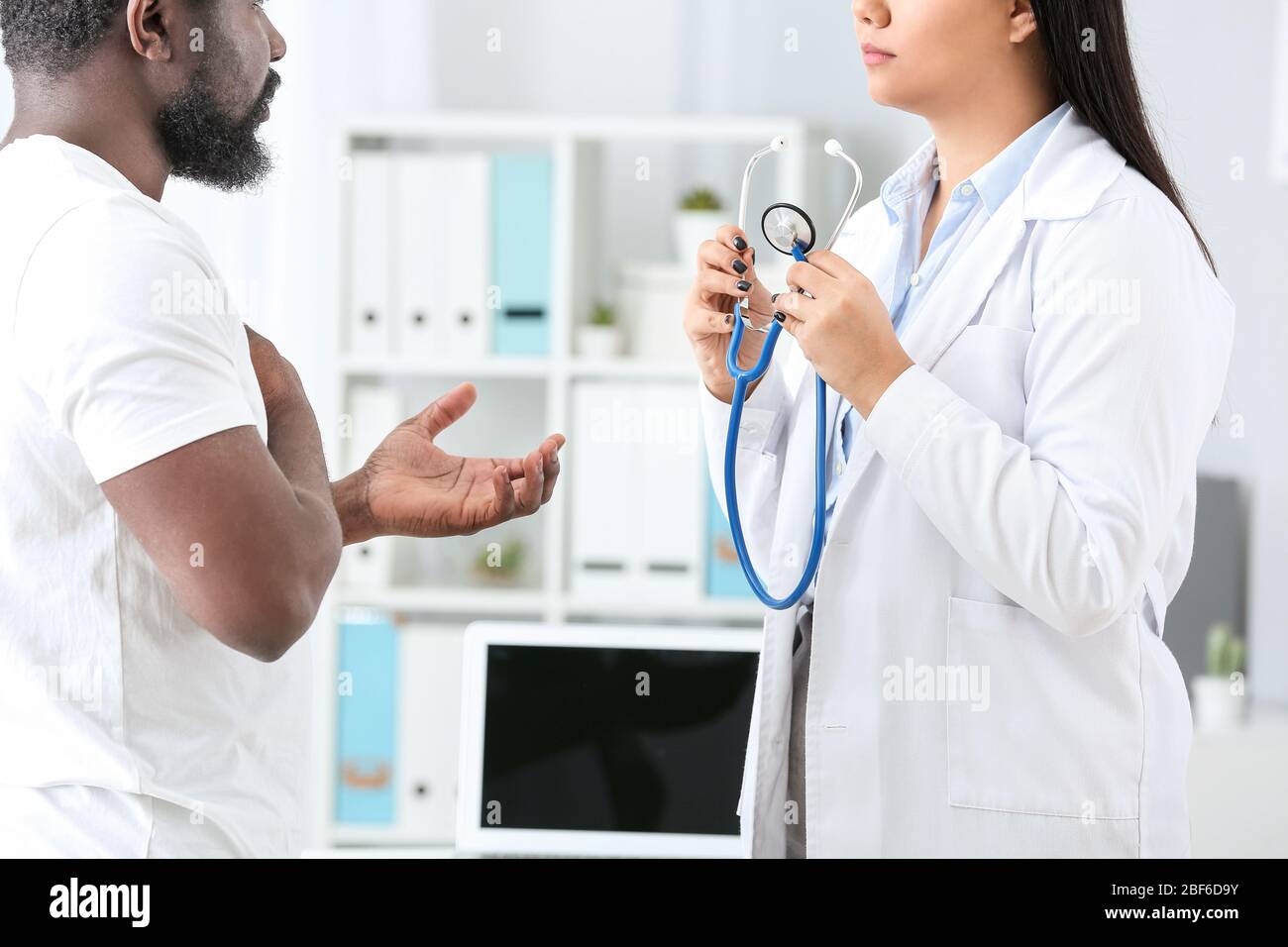 Young man visiting female cardiologist in clinic Stock Photo - Alamy