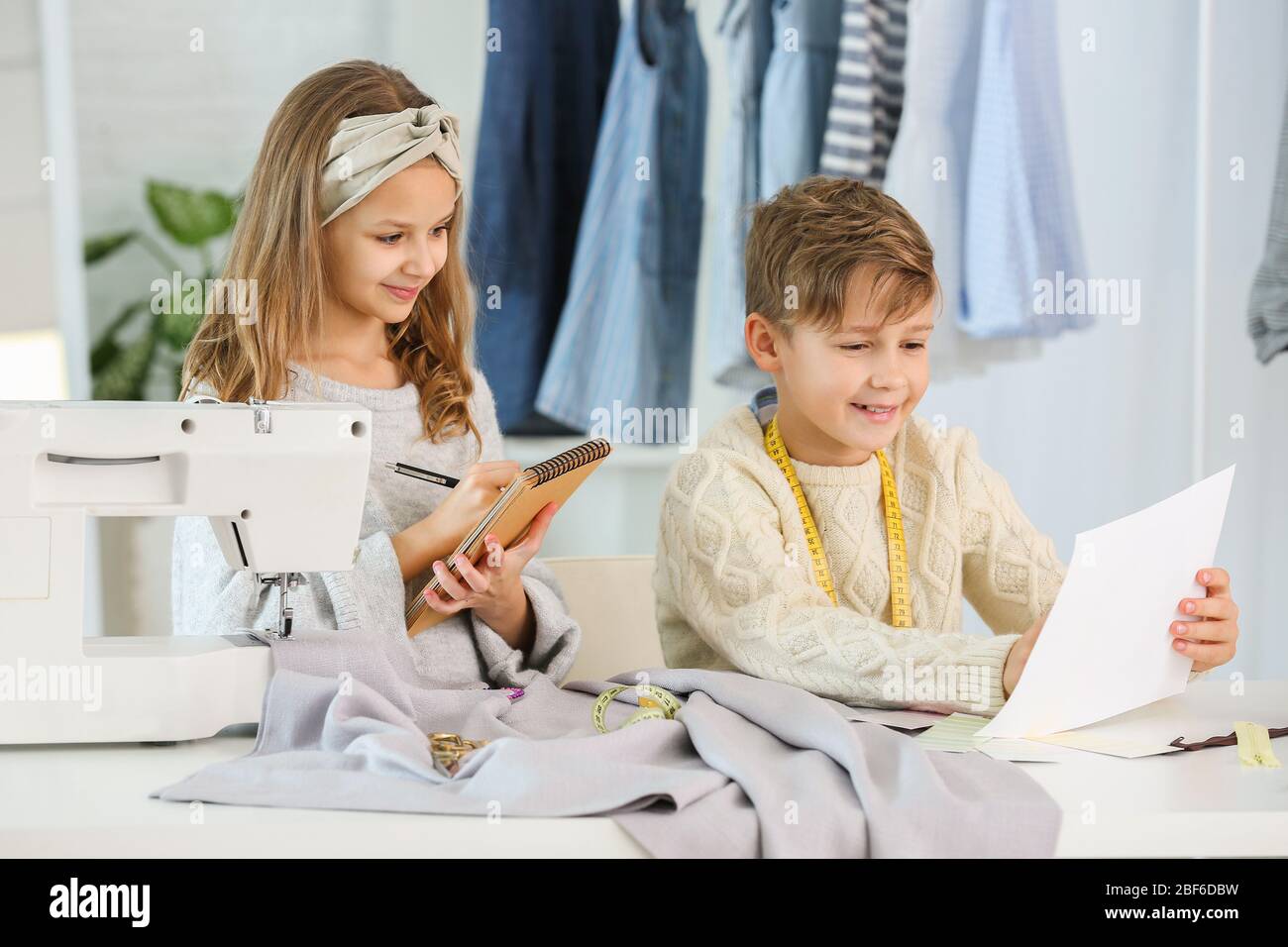 Cute little tailors working in atelier Stock Photo - Alamy