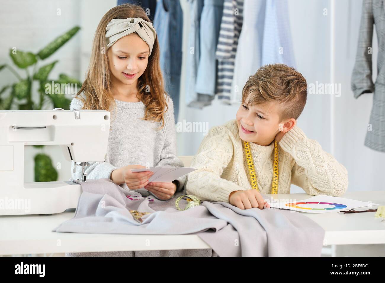 Cute little tailors working in atelier Stock Photo - Alamy