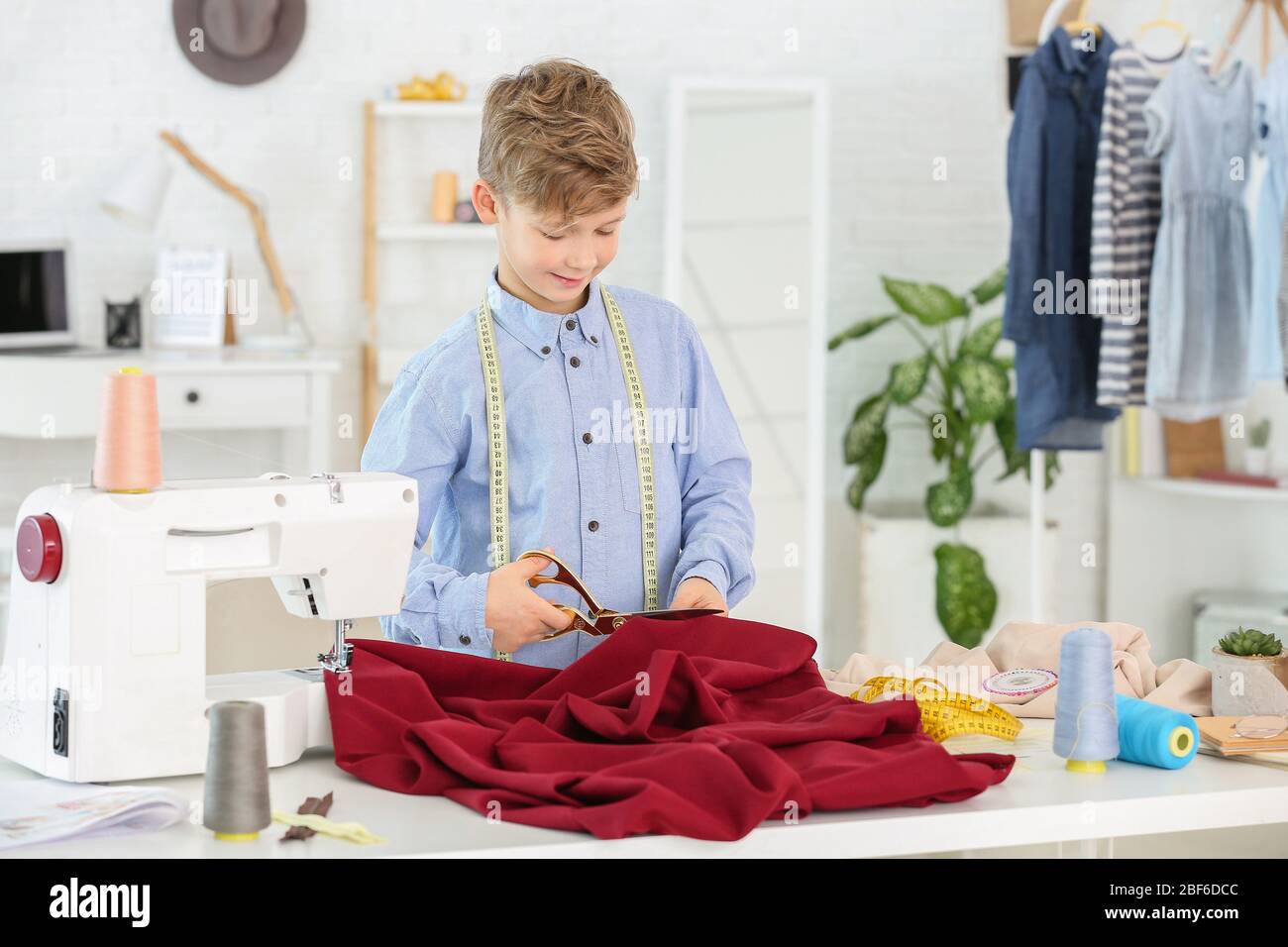 Cute little tailor working in atelier Stock Photo - Alamy