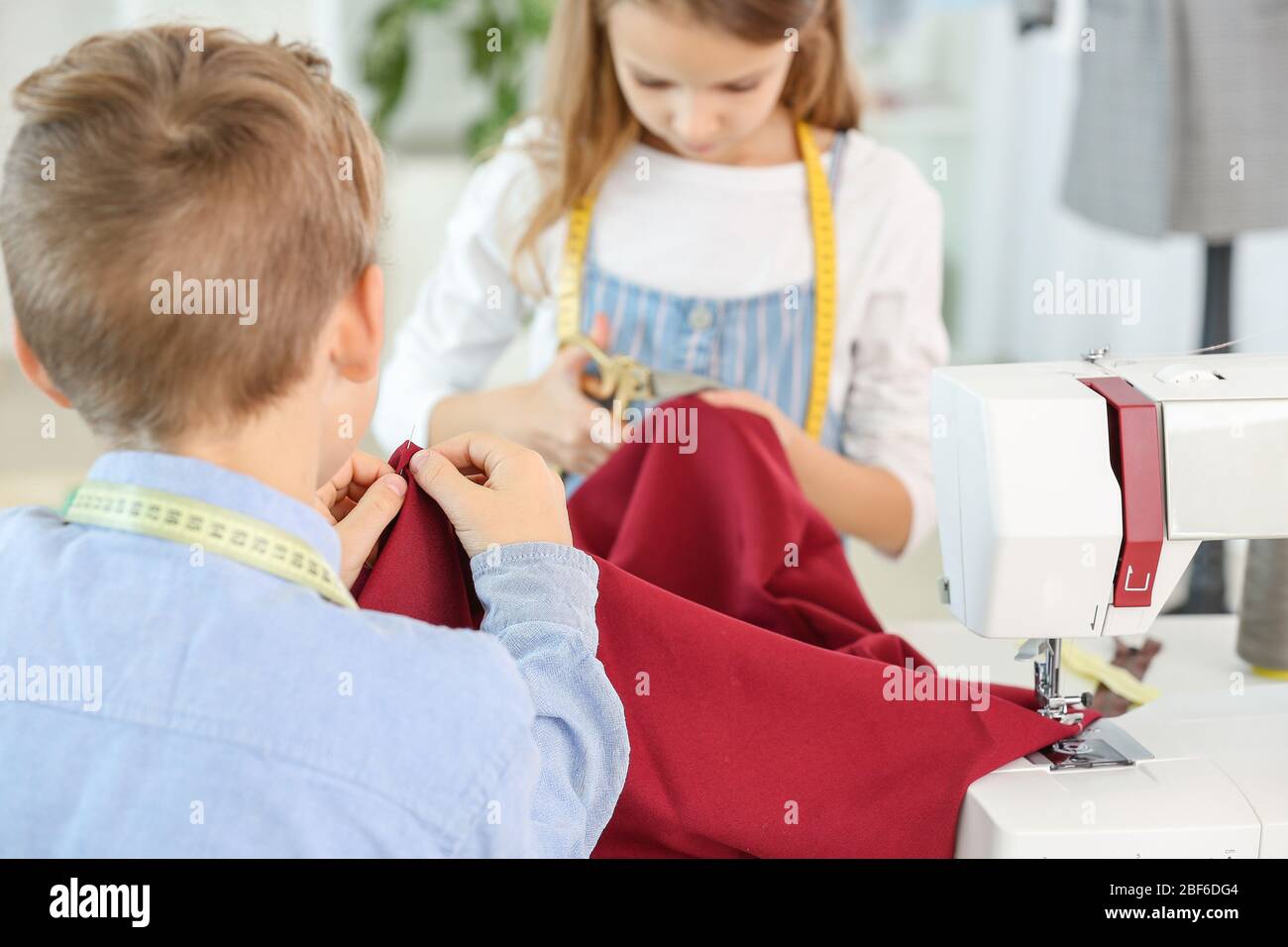 Cute little tailors working in atelier Stock Photo - Alamy