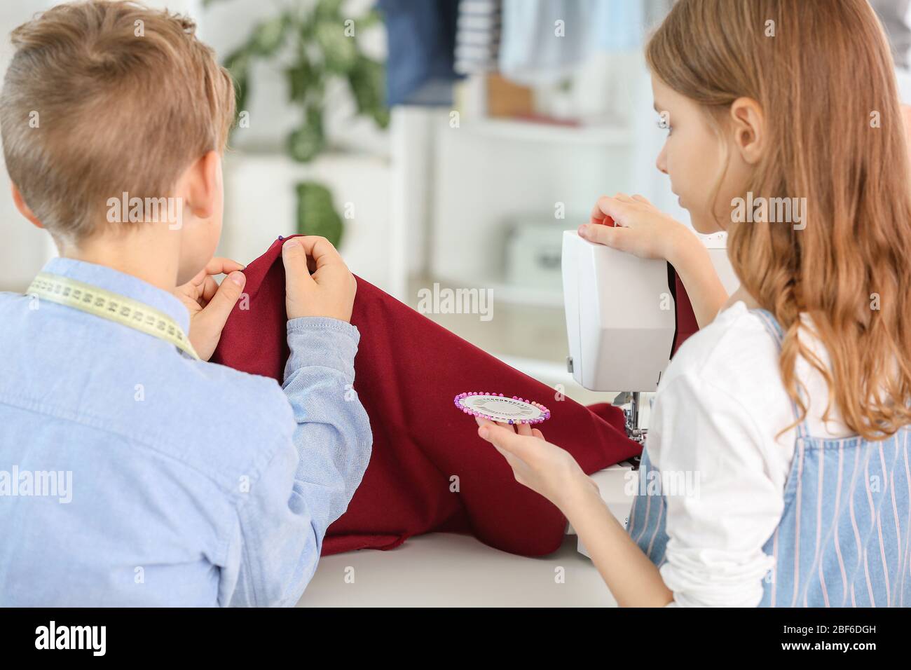 Cute little tailors working in atelier Stock Photo - Alamy