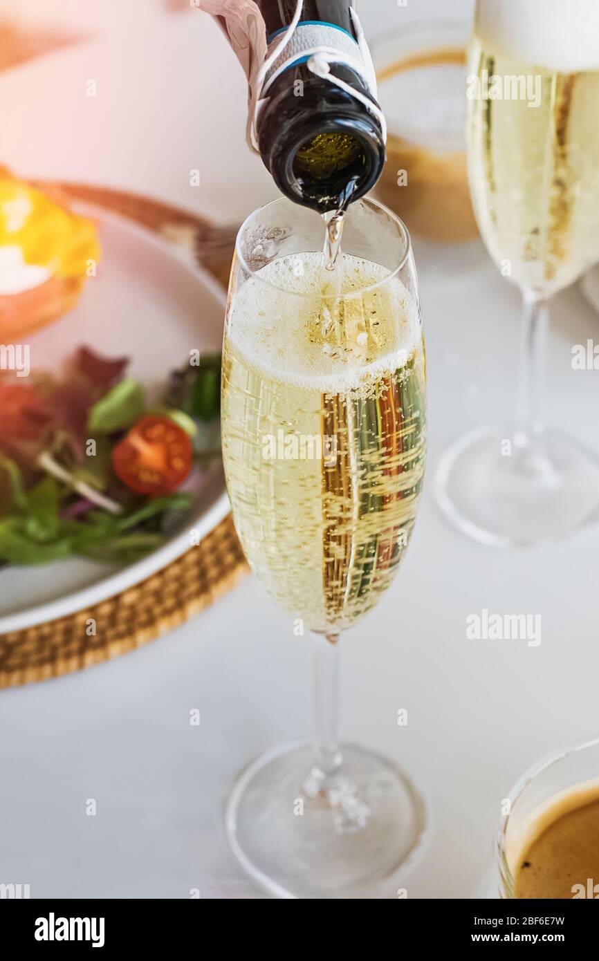 Pouring prosecco sparkling wine in a glass on sunday brunch Stock Photo ...