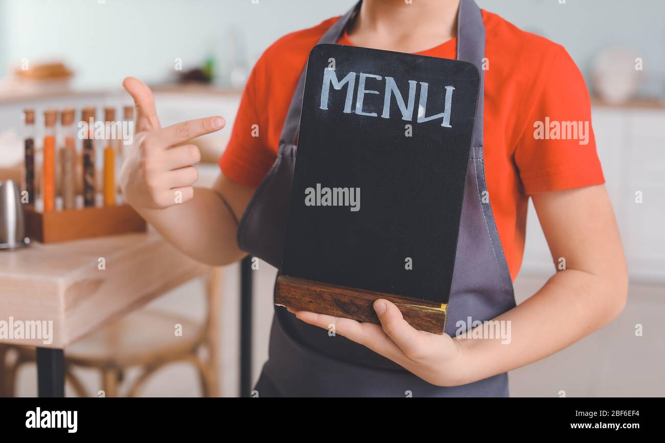 Cute little chef with menu in kitchen Stock Photo - Alamy