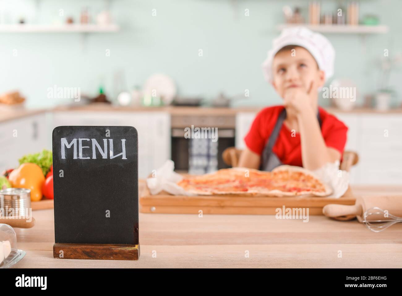 Blank menu and cute little chef in kitchen Stock Photo - Alamy