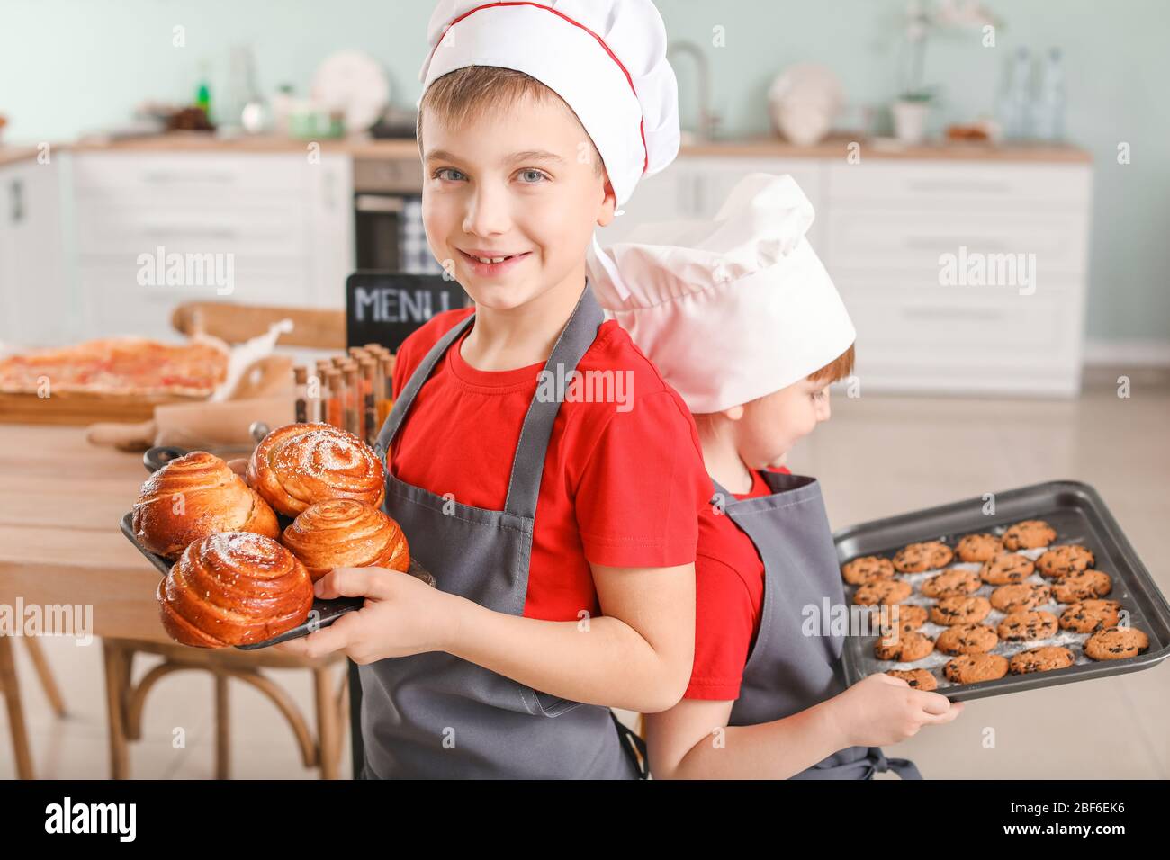Cute little chefs with pastry in kitchen Stock Photo - Alamy