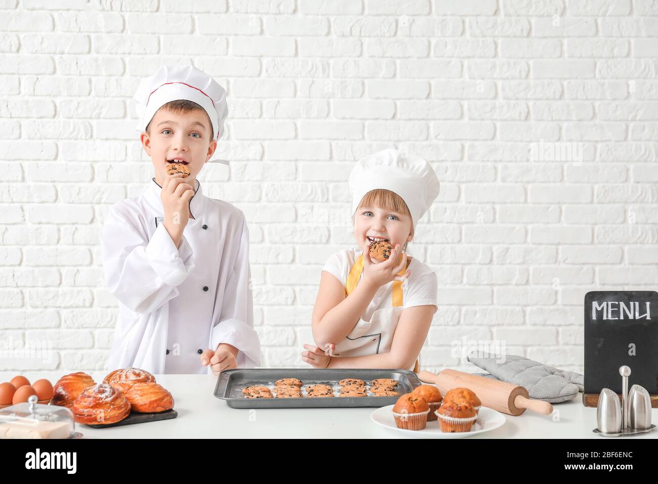 Cute little chefs with pastry on white background Stock Photo - Alamy