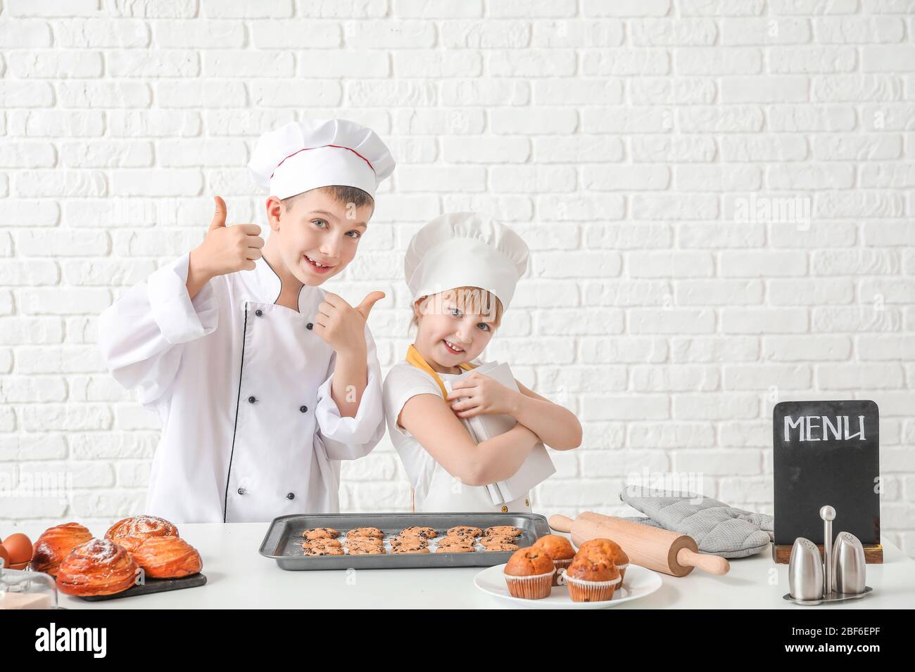 Cute little chefs with pastry on white background Stock Photo - Alamy