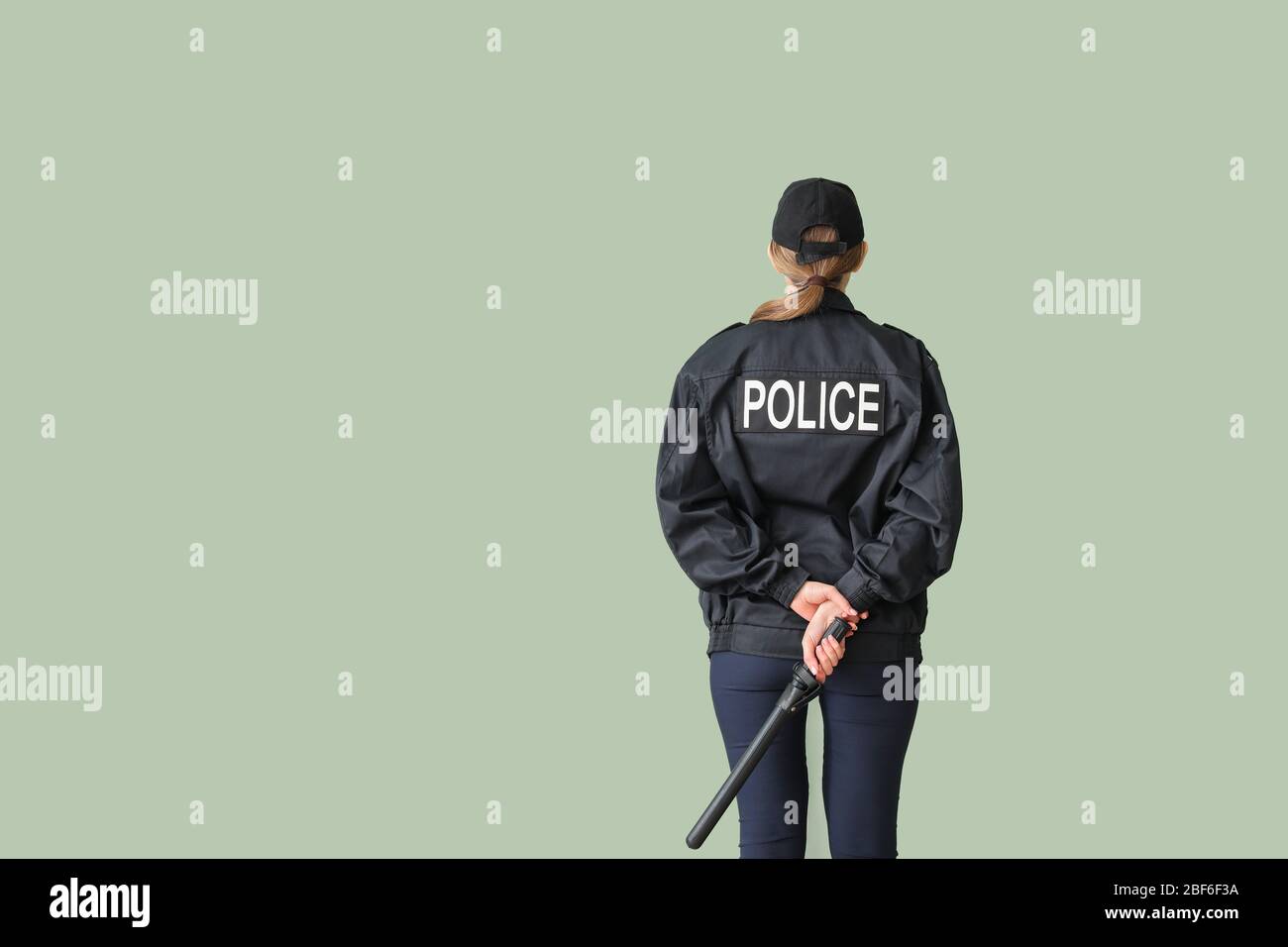 Female police officer on color background, back view Stock Photo - Alamy
