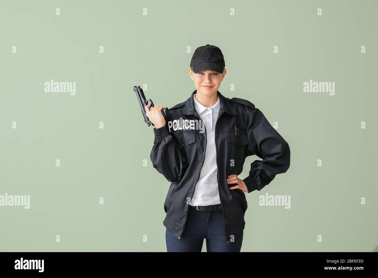 Female police officer with gun on color background Stock Photo - Alamy