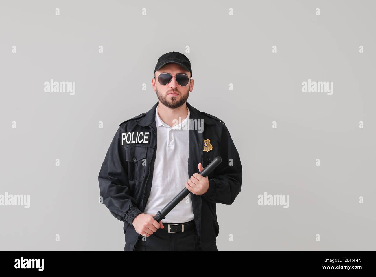 Male police officer on light background Stock Photo - Alamy