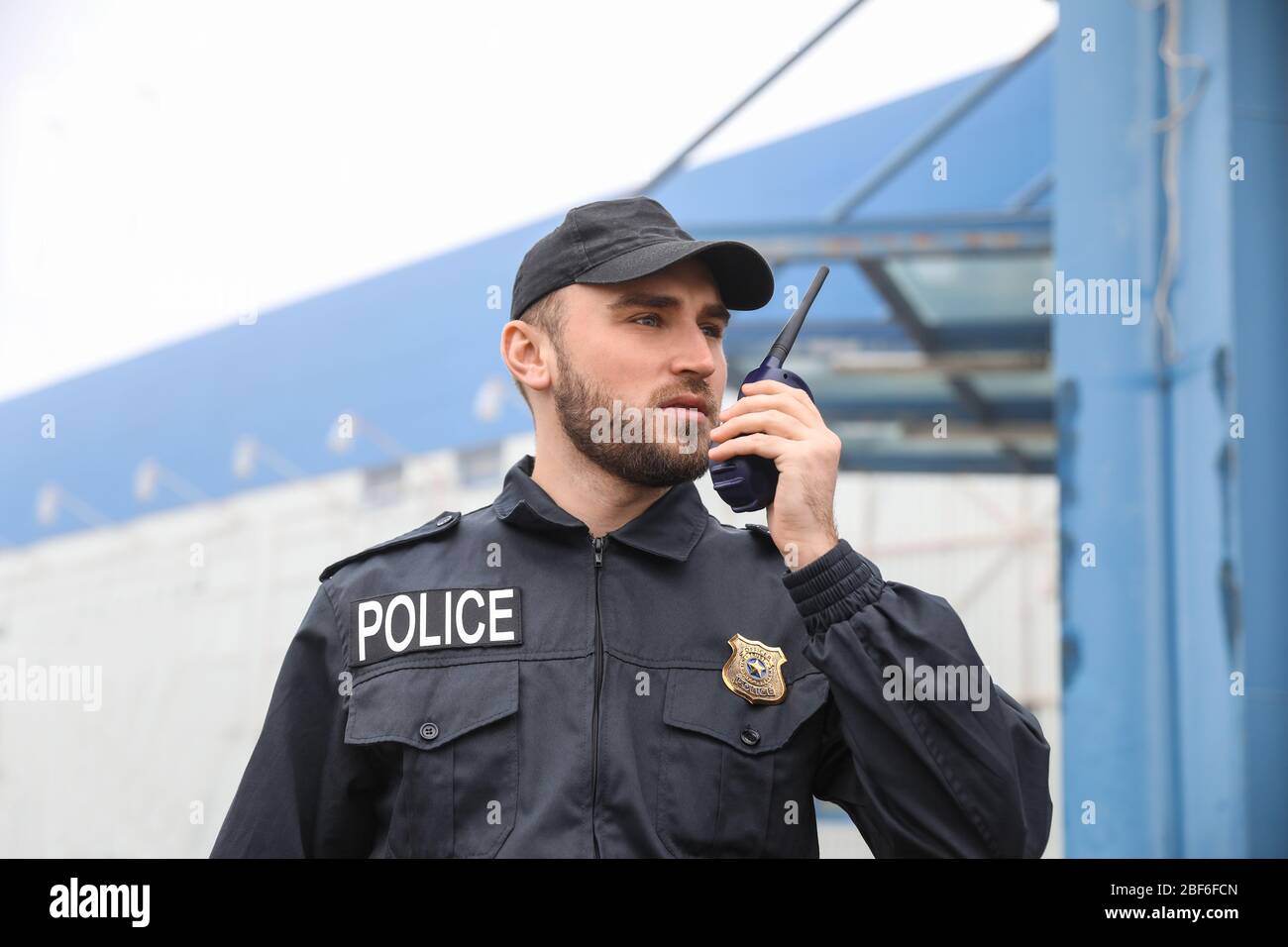 Male police officer patrolling city street Stock Photo - Alamy