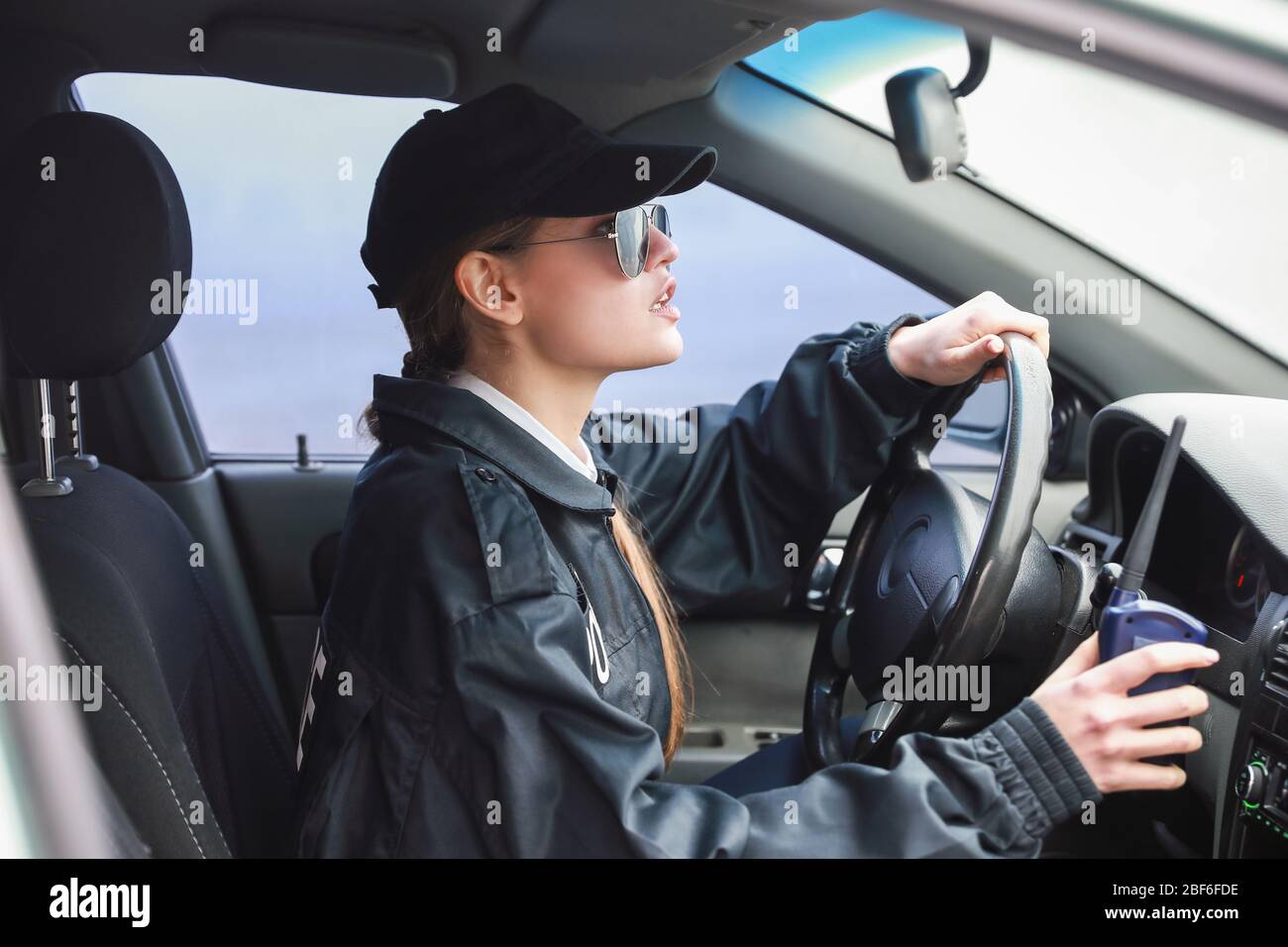 Female police officer driving car Stock Photo - Alamy