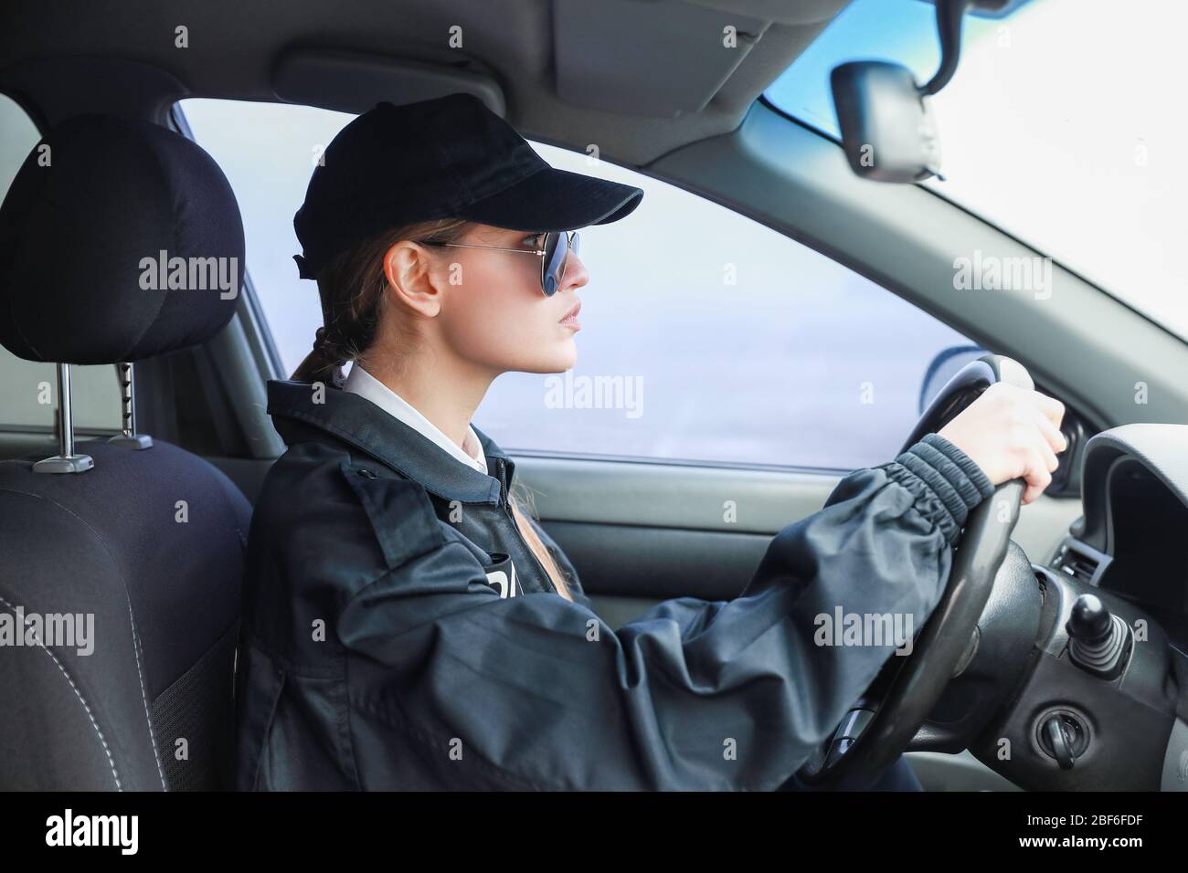 Female police officer driving car Stock Photo - Alamy