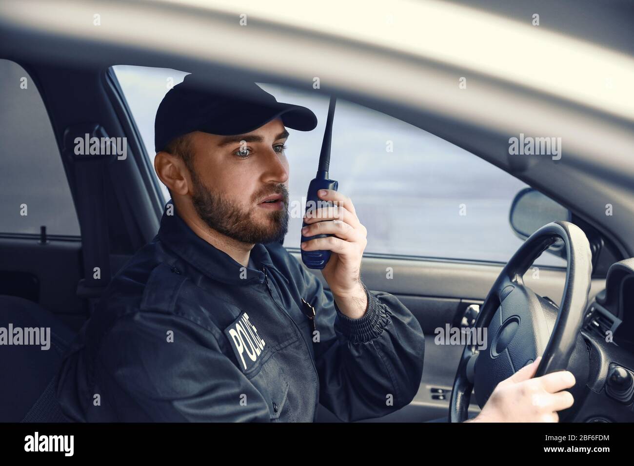 Male police officer driving car Stock Photo - Alamy