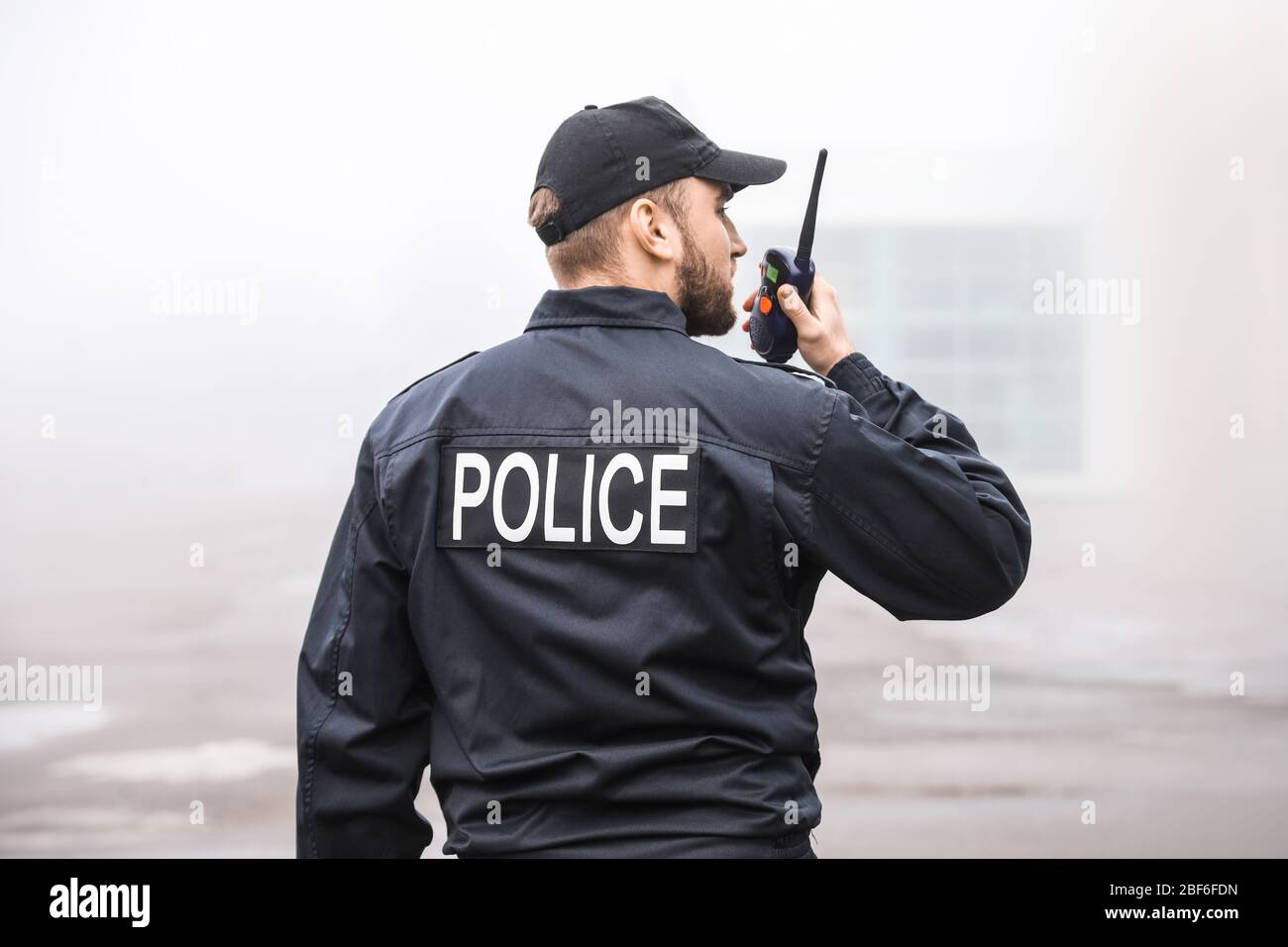 Male police officer patrolling city street Stock Photo - Alamy
