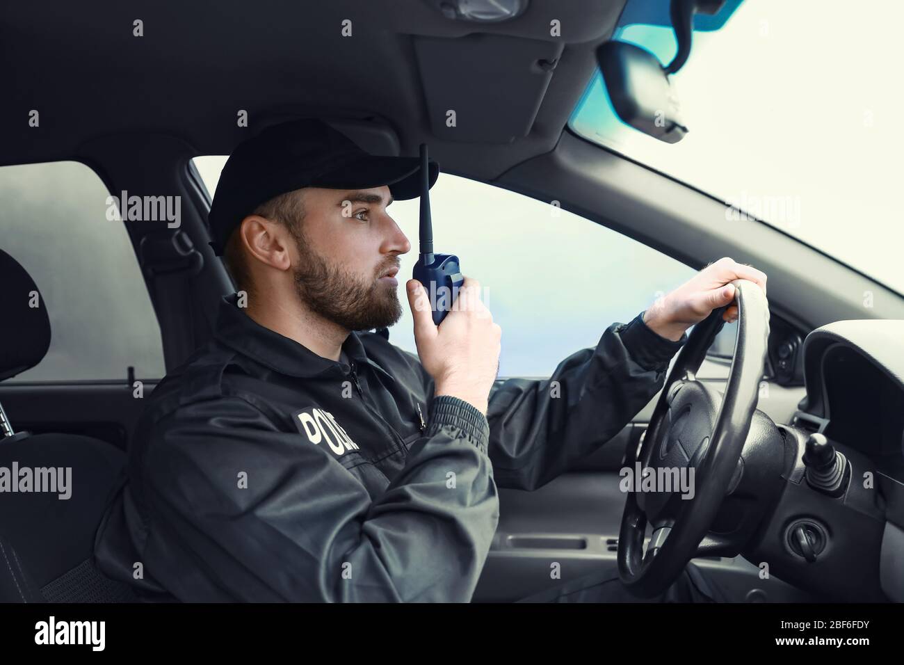 Male police officer driving car Stock Photo - Alamy