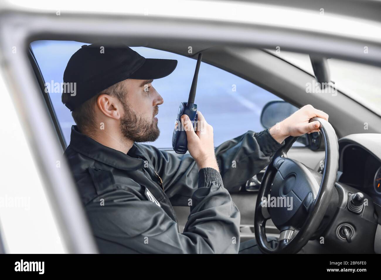 Male police officer driving car Stock Photo - Alamy