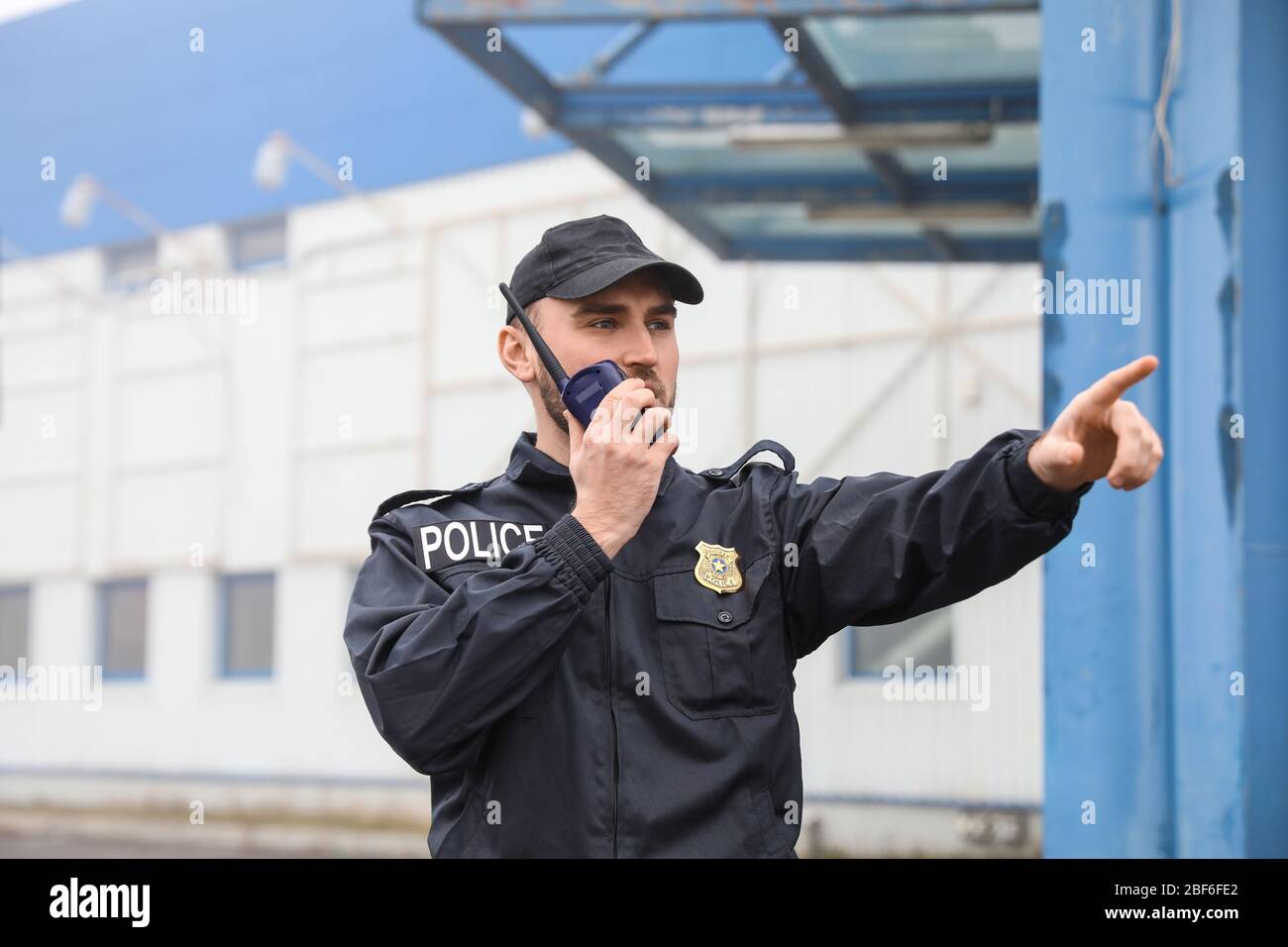 Male police officer patrolling city street Stock Photo - Alamy